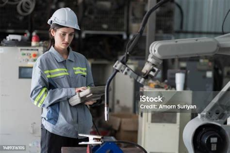 산업 제조 로봇 팔 여성 엔지니어 노동자 통제 자율적인 로봇 공학 팔 용접 기계 생산 공장 공장에 있는 제조 선 25 29세에