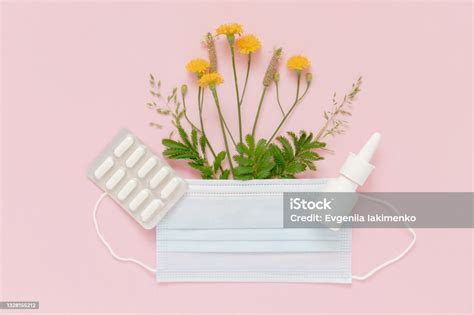 보호 마스크 아래 야생 꽃과 허브 비강 스프레이의 모형과 밝은 분홍색 배경에 정제와 물집 계절 알레르기의 보호 및 치료의 수단의 개념 꽃 식물에 대한 스톡 사진 및 기타