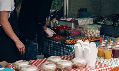 거리 음식 축제입니다 남자 토마토 슬라이스가 패스트 푸드 걸릴 요리 형태와 장갑 샐러드와 바베 큐 요리사 케이터링 야외 부엌에 엽니다 여름 피크닉 7월에 대한 스톡 사진 및