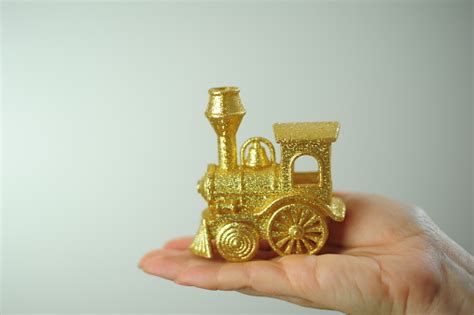크리스마스 트리를위한 황금 증기 기관차 장난감 손바닥에 누워 흰색 배경에 새해 문자 초대 장소가 있습니다 공휴일에 대한 스톡