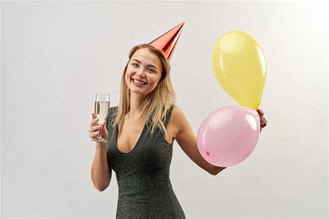 잔 그녀의 머리와 손에 Amiably 널리 웃 고는 카메라 보고 풍선에 샴페인 축제 모자와 드레스를 입은 매력적인 웃는 소녀 겨울에 대한 스톡 사진 및 기타 이미지 Istock