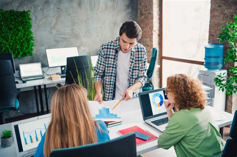 Group Of Diverse Professionals Collaborating In A Modern Office Setting Discussing Charts And