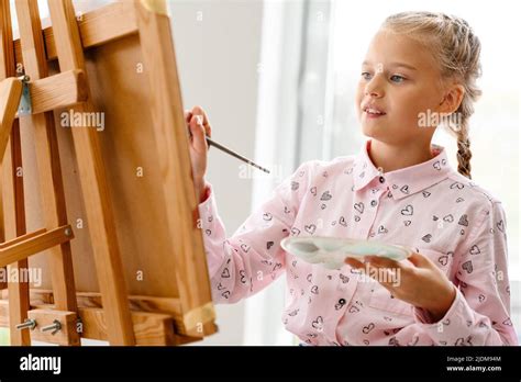 White Blonde Girl Drawing During Class In Art School Indoors Stock