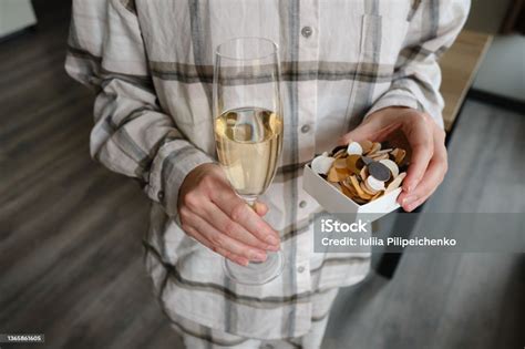 한 잔의 와인이나 샴페인을 소녀의 손에 들고 색종이 한 상자 알코올 음료의 맛 축하하고 순간을 즐길 수 있습니다 휴일을 위한 축제 장식 12월 31일에 대한 스톡 사진 및