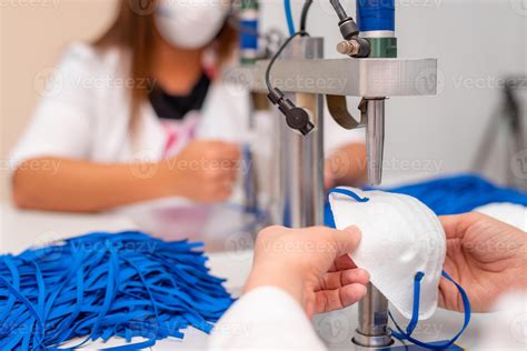 Women Work At A Machine For The Manufacture Of Medical Masks With