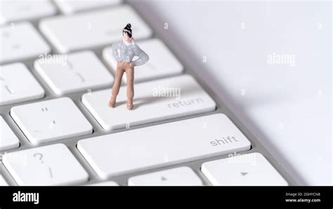 Female Miniature Standing On The Return Key Of White Keyboard Stock Photo Alamy
