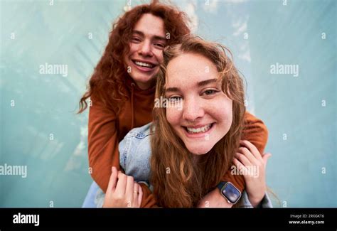 Playful Portrait Of Sister And Brother With Redhead Hugging Looking At