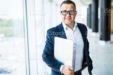 비즈니스 전문가입니다 노트북을 들고와 서 사무실에 있는 동안 카메라를 보고 공식적인 마모에 자신감 수석 남자 남자에 대한 스톡 사진 및 기타 이미지 Istock