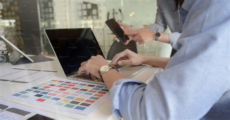 간단한 공동 작업 공간에서 흰색 책상에 노트북과 스마트폰으로 Ui 프로젝트에 집중하는 애플리케이션 개발자 팀의 클로즈업 보기