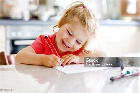 집에서 화려한 연필로 귀여운 아기 유아 소녀 그림 사랑스러운 건강한 행복한 아이 학습 그림 펠트 팁 펜을 유혹하여 실내 또는 보육원에서 즐거운 시간을 보내는 활동적인 아이