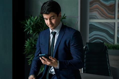 손에 휴대 전화를 가진 정장을 입은 사업가 소셜 넷을 사용하여 메시지를 입력하는 남자 뉴스 확인 비즈니스 미팅 만들기 현대적인 사무실 일반 관리자 Ceo 파트너에게 전화하기