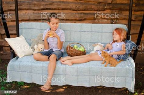 정원에서 동생이 사과를 먹고 그네 마을에서 행복한 평온한 어린 시절 빨간 새끼 고양이와 함께 웃고있는 아이들 2명에 대한 스톡 사진 및 기타 이미지 Istock