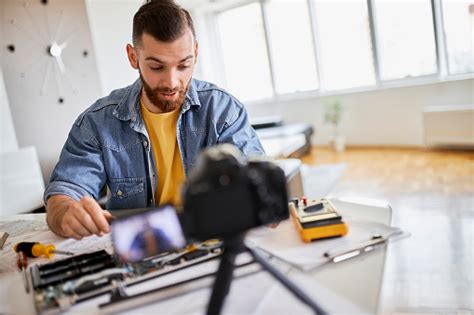 작업장에서 남성 영향력자는 자신의 하루 일을하고 튜토리얼을 촬영 전기 회로 수리에 필요한 다양한 도구와 품목으로 가득찬 작업