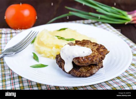 Juicy Liver Cutlet With Sauce And Mashed Potatoes On A White Plate