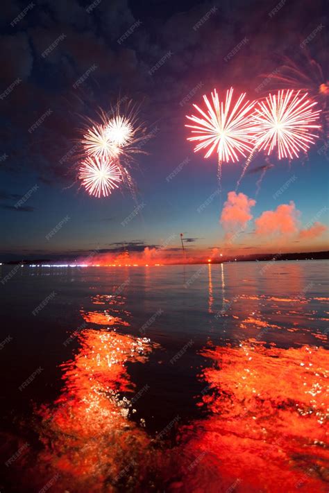 Fogos De Artifício De Férias Acima Da água Com Reflexo No Fundo Do Céu Negro Foto Premium