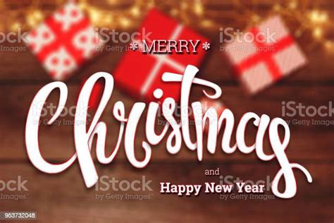 메리 크리스마스와 해피 뉴가 어 선물 환과 화 나무 갈색 테이블에 비문 크리스마스 카드 크리스마스 배경입니다 혼합 미디어입니다