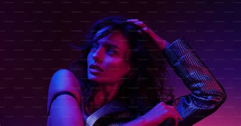 스튜디오에서 화려한 네온 불빛으로 패셔너블한 드레스를 입은 패션 여성 모델 나이트 클럽에서 밝은 분홍색과 보라색 자외선 위에 트렌디한 옷을 입은 세련된 섹시한 소녀의