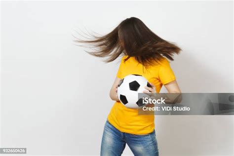 아름 다운 유럽 젊은 여자 축구 팬 또는 흰색 배경에 고립 된 머리를 나 부 끼고 축구 공을 들고 노란색 유니폼에 선수 스포츠 축구 건강 건강 한 라이프 스타일 컨셉 놀이