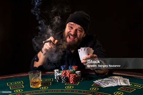 남자는 시가와 위스키와 포커를 재생 하 고 남자는 두꺼운 담배 연기와 테이블에 있는 모든 칩을 승리 손에 두 개의 카드를 보여줍니다 권위에 대한 스톡 사진 및 기타 이미지