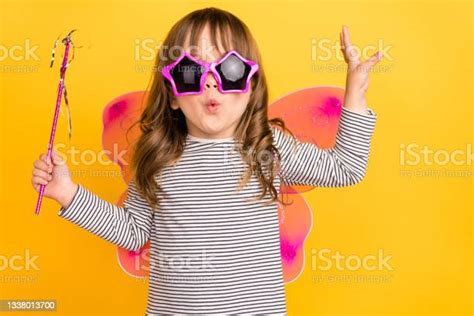 사진 멋진 작은 금발 머리 소녀 보유 스틱 착용 날개 안경 지팡이 줄무늬 셔츠 에 단색 된 노란색 색상 배경 곱슬 머리에 대한 스톡 사진 및 기타 이미지 Istock