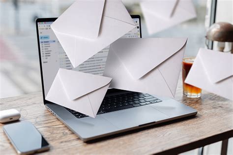 웹메일 서비스 사이트가 열려 있고 사무실에서 우편물을 보내는 노트북이 도시를 배경으로 테이블 위에 서 있습니다 메일과 일 컨셉 수신 메일 창의적인 아이디어 비행 알림 우편물