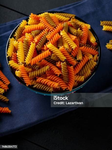 어두운 나무 배경에 그릇에 담긴 원시 푸실리 파스타 파란색 린넨 냅킨에 삼색 Fusilli 파스타 평면도 복사 공간 건강한 식생활에 대한 스톡 사진 및 기타 이미지 Istock