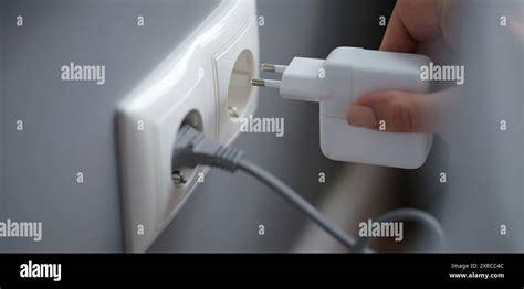 Female Fingers Plug The Power Adapter Into An Outlet Stock Photo Alamy