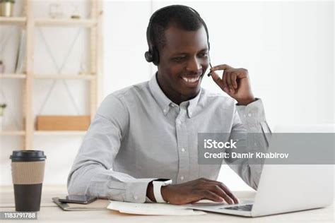 노트북에서 작업하는 동안 헤드폰을 착용한 아프리카 남성 고객의 전화에 응답 20 29세에 대한 스톡 사진 및 기타 이미지 20 29세 계획 고객 서비스 담당자