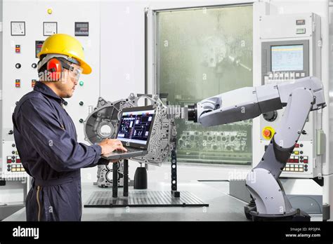 Engineer Using Laptop Computer Control Automatic Robotic Hand With Cnc Machine In Automotive