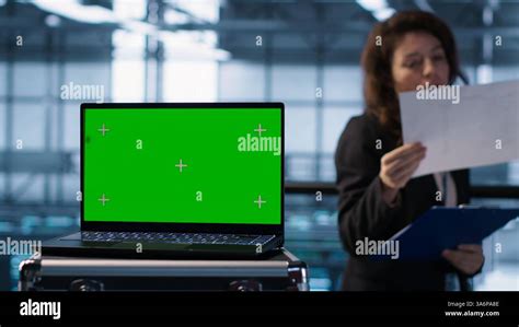 Green Screen Laptop Used By Data Center Admins In Blurry Background Reviewing Equipment