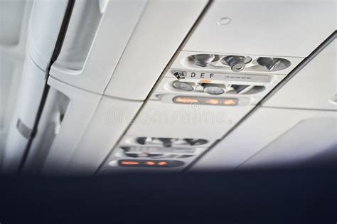 the buttons are located on the ceiling of a passenger aircraft where safety elements such as an