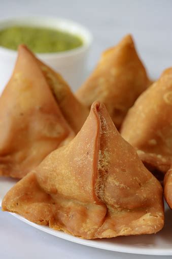 민트 고수 딥 대리석 효과 배경의 라메킨 외에 매운 감자 완두콩 고기로 채워진 흰색 접시에 튀긴 사모사 튀김 이미지 전경에 초점을 맞추고 사모사에 대한 스톡 사진 및 기타