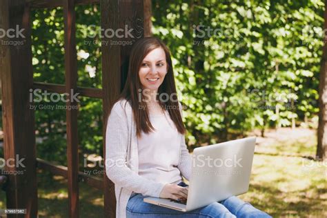 가벼운 캐주얼 옷에 젊은 성공적인 사업가 봄 자연에 야외 거리에 도시 공원에서 현대 노트북 Pc 컴퓨터에서 작업 하는 여자를 웃 고 모바일 사무실입니다 프리랜서 비즈니스