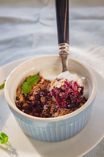 구운 귀리 블루베리는 소박한 린넨 식탁보에 흰색과 파란색 접시에 민트와 함께 무너져 공간 상단 보기를 저장합니다 아침 식사 채식주의에 대한 건강한 적절한 영양의 개념 건강한