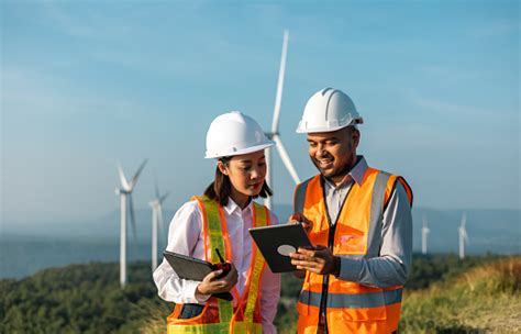 풍차 농장에서 일하는 두 명의 엔지니어 남자와 여자가 전기 청정 에너지를 생성합니다 대체 녹색 에너지에 의한 풍력 터빈 농장