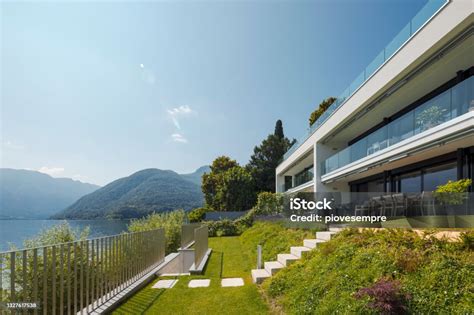 세레시오 호수에 바로 아름다운 정원이있는 두 아파트의 현대적인 집 푸른 하늘과 화창한 날 미니멀하고 선형아키텍처입니다 호수의 탁 트인 전경 텍스트 공간 스위스에 대한 스톡