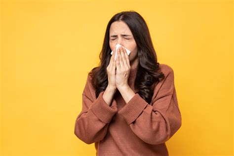 나이 적은 편의 아픈 여자 가지고 알레르기 와 재채기 에서 조직 통하고 있는 노란 배경 스톡 사진 감기와 독감에 대한 스톡 사진