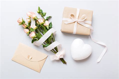 복사 공간 분홍색 리본 장미 꽃이 있는 인사말 카드 모형은 컬러 테이블 배경에 있다 평평한 위치 평면도 어머니의 날 휴일 개념