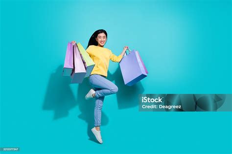 흥분 달콤한 아가씨 옷을 입은 노란색 스웨터 점프 보유 쇼핑객 빈 공간 외딴 청록색 배경 의 전체 길이 사진 20 24세에 대한 스톡 사진 및 기타 이미지 Istock