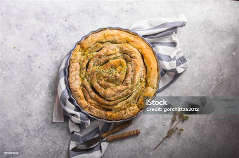 콘크리트 배경 위에 그리스 어 파이 스파나코 피타 필로 페이스트리에서 채식 또는 비건 시금치 파이에 대한 아이디어와 조리법은 슬라이스로 잘라 공간을 복사합니다 상단 보기