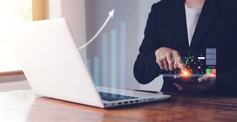 성공 비즈니스 개념 주식 차트 또는 암호 해독의 구매 및 판매 사업가는 스마트 폰과 노트북 으로 차트의 홀로그램을 손으로 터치합니다 통계 그래프 및 숯 성장 그래프 거래자에