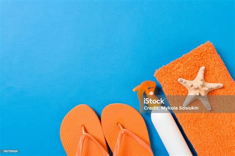 해변 플랫 레이 액세서리의 상단보기 조개 불가사리 수건 및 플립 플롭과 복사 공간이있는 컬러 배경의 선스크린 병 개념에 대한