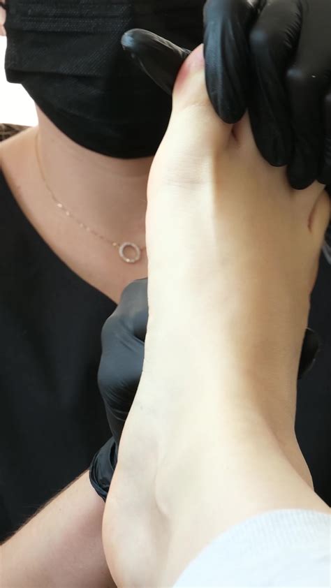 Professional Foot Massage In Pedicure Salon Foot Care Woman Doctor In Black Gloves Doing Massage