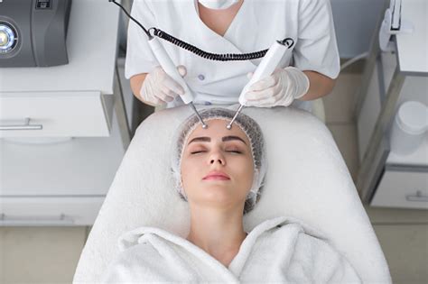 매크로는 스파에서 화장품 갈바닉 뷰티 트리트먼트를 받는 여성의 초상화를 클로즈업합니다 얼굴에 전극으로 저주파 전류를 적용하는