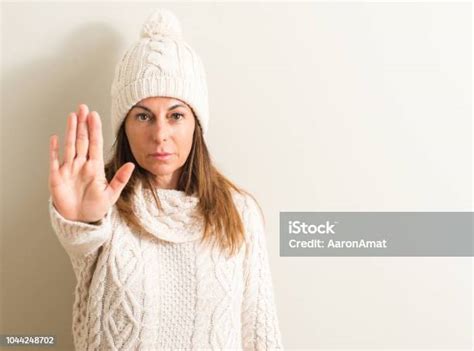 심각 하 고 자신감 표현 방어 제스처 정지 표시를 하 고 오픈 손으로 모직 겨울 모자를 착용 해 중간 나이 여자 갈색 머리에 대한 스톡 사진 및 기타 이미지 Istock