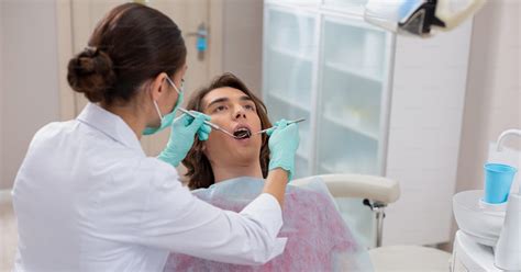 치과 교정기 검사 여성 치과 의사가 치과 브래킷을 확인하는 동안 의자에 앉아 입을 벌린 남성 환자 사진 Unsplash의 치과 교정기 이미지