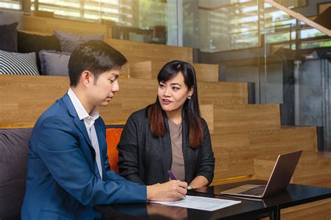 현대 사무실에서 일하고 계약을 협상하는 두 명의 아시아 비즈니스 종사자 비즈니스 파트너가 함께 일하고 새로운 프로젝트에 대한 계약을 체결합니다 변호사에 대한 스톡 사진 및