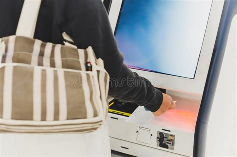 Woman Passenger Doing Self Check In Scanning Boarding Pass At Airport Woman Passenger Doing Self Check In Scanning Boarding Pass At Airport