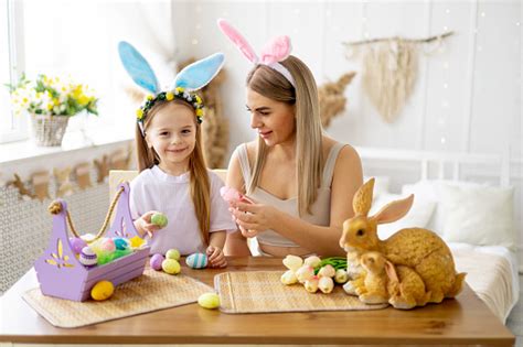 부활절 머리에 토끼 귀를 가진 어린 딸을 둔 어머니는 계란을 색칠하고 놀고 라이프 스타일 부활절을 위해 아이와 함께 행복한 가정을 준비하여 휴가를 준비하고 있습니다 2 3