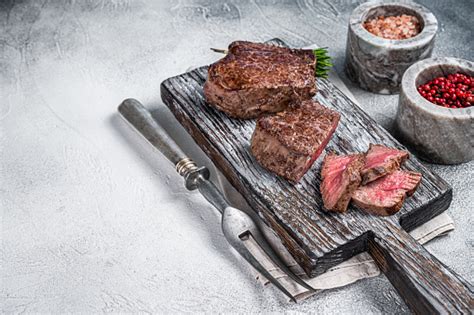 구운 필렛 미뇽 또는 부드러운 쇠고기 스테이크를 나무 도마에 구워 흰색 배경입니다 맨 위 보기입니다 복사 공간 검은색에 대한 스톡 사진 및 기타 이미지 Istock